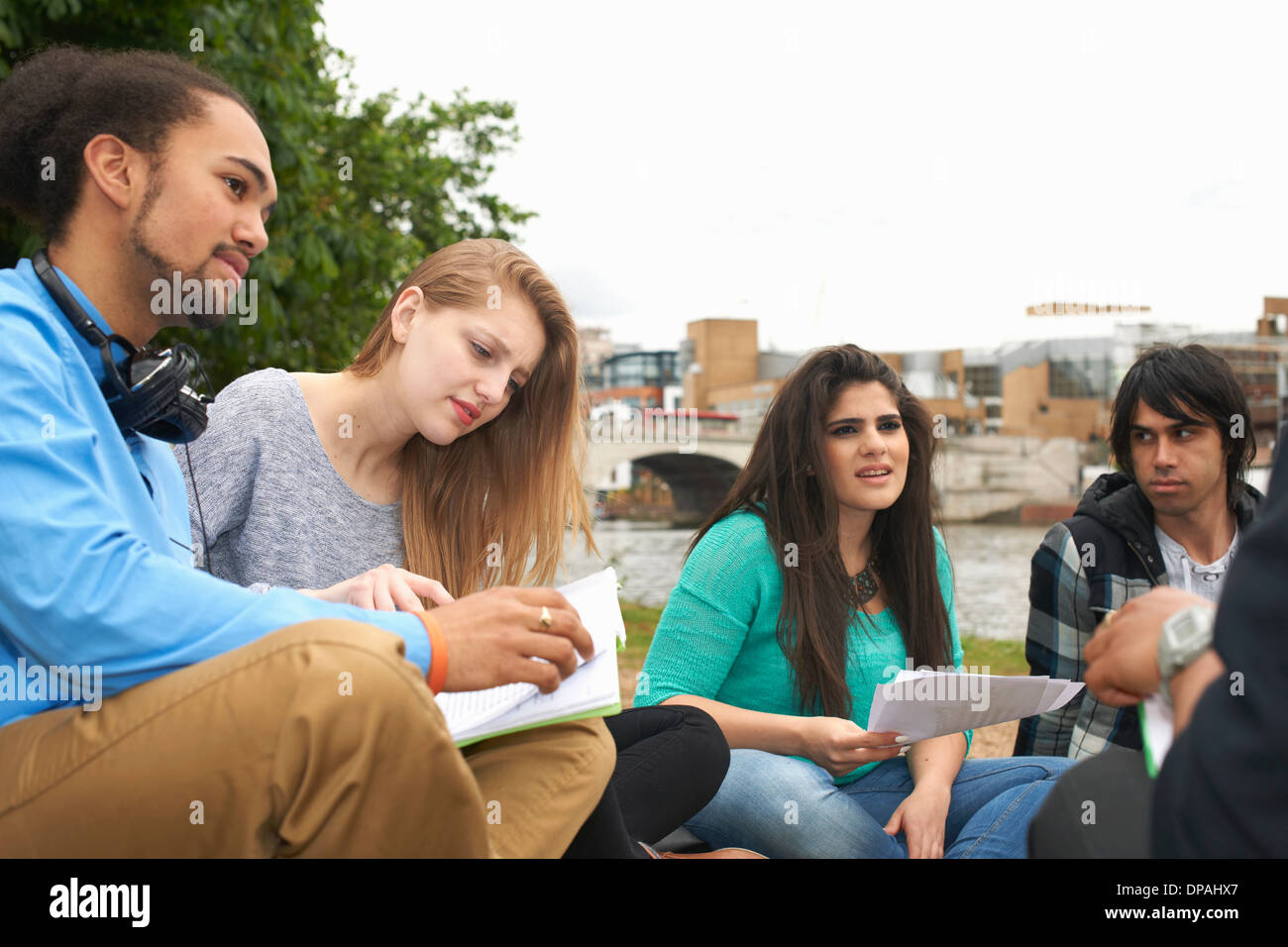 College students sitting outdoors with papers Stock Photo - Alamy