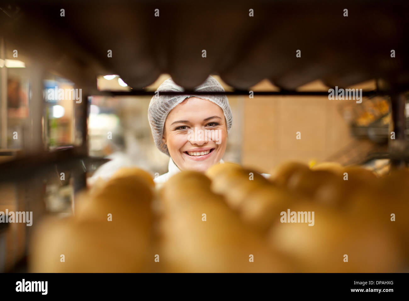 Portrait of young baker and tray of bread rolls Stock Photo - Alamy