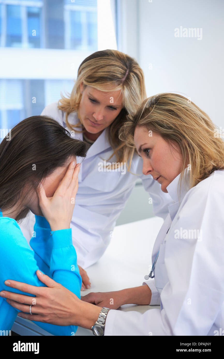 Female doctors comforting patient Stock Photo - Alamy