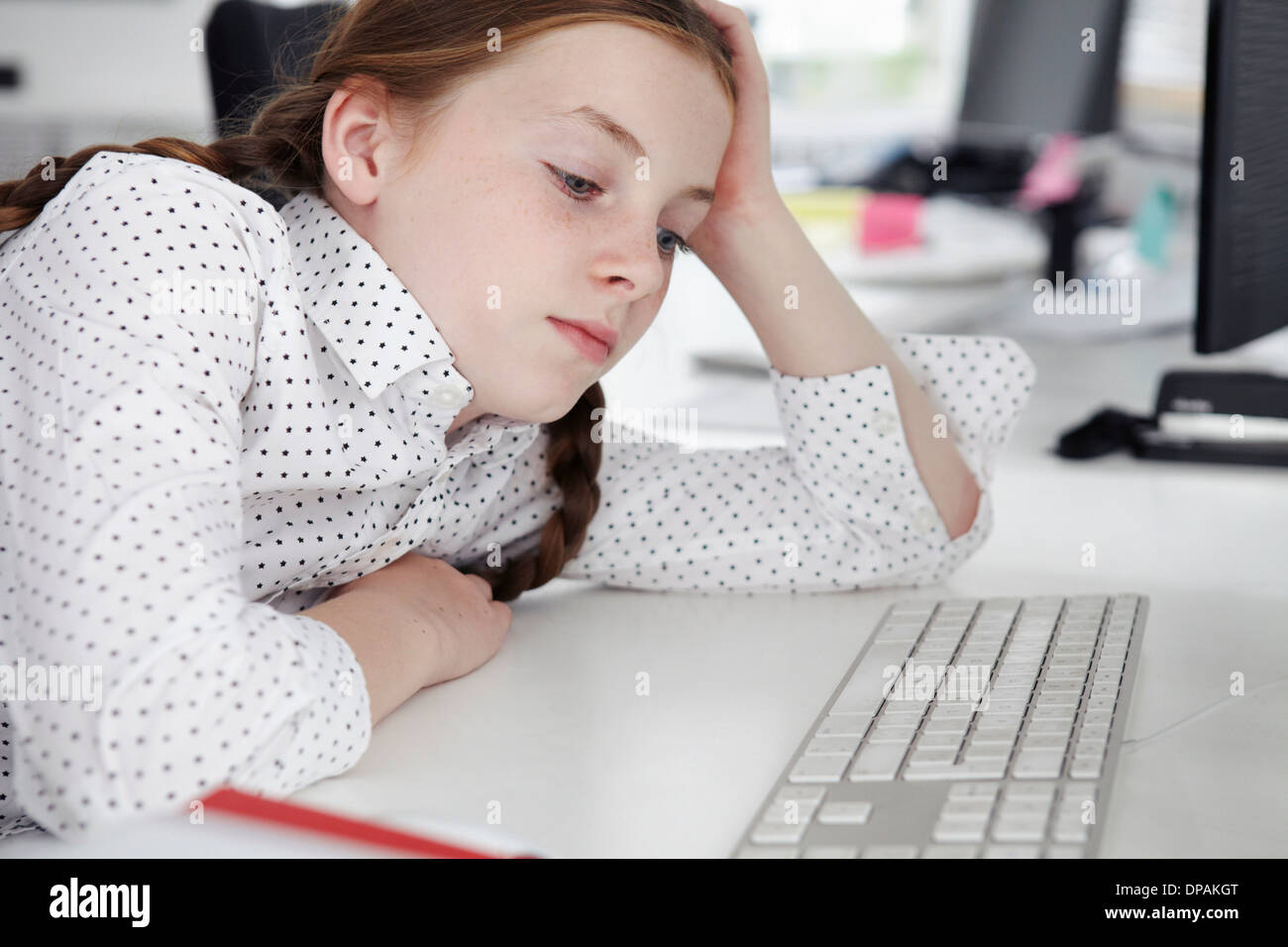 Girl staring at computer keyboard Stock Photo - Alamy