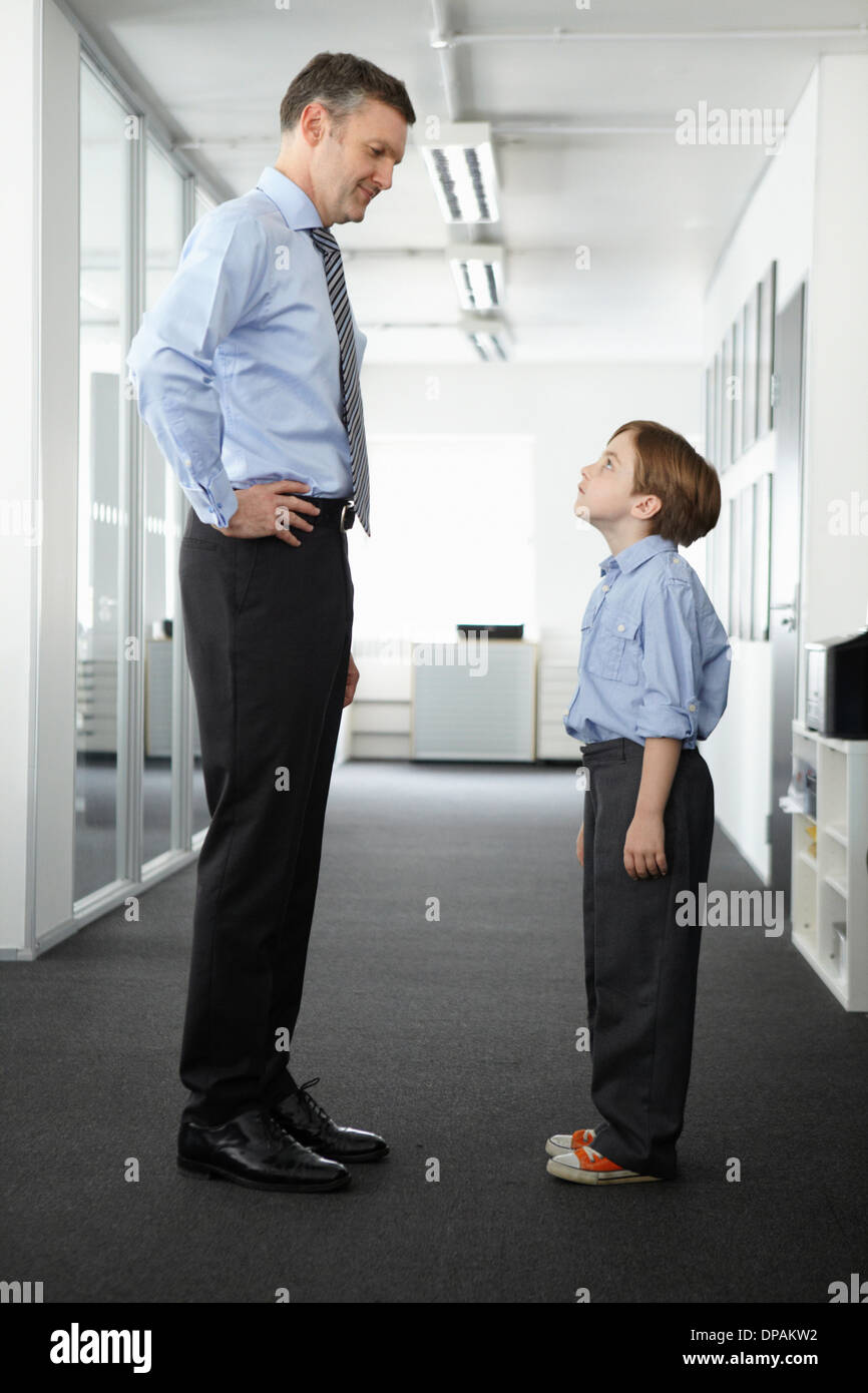 Father and son standing face to face in office Stock Photo - Alamy