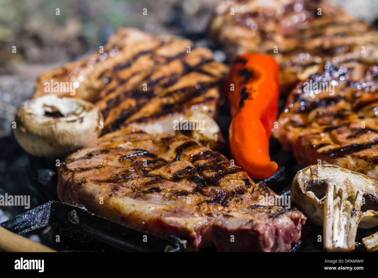Meat steak on grill with vegetables Stock Photo - Alamy