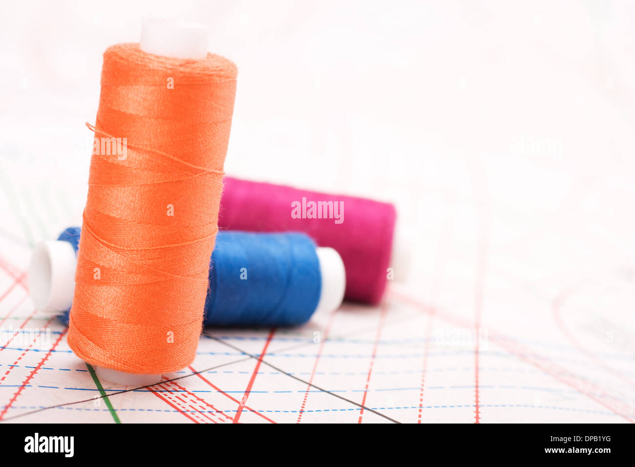 Spool of thread. Sew accessories on blurred background Stock Photo - Alamy