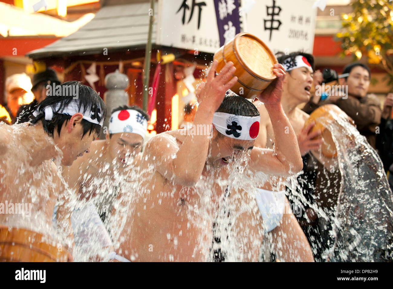 Tokyo, Japan. 11th Jan, 2014. Participants pour themselves cold water ...