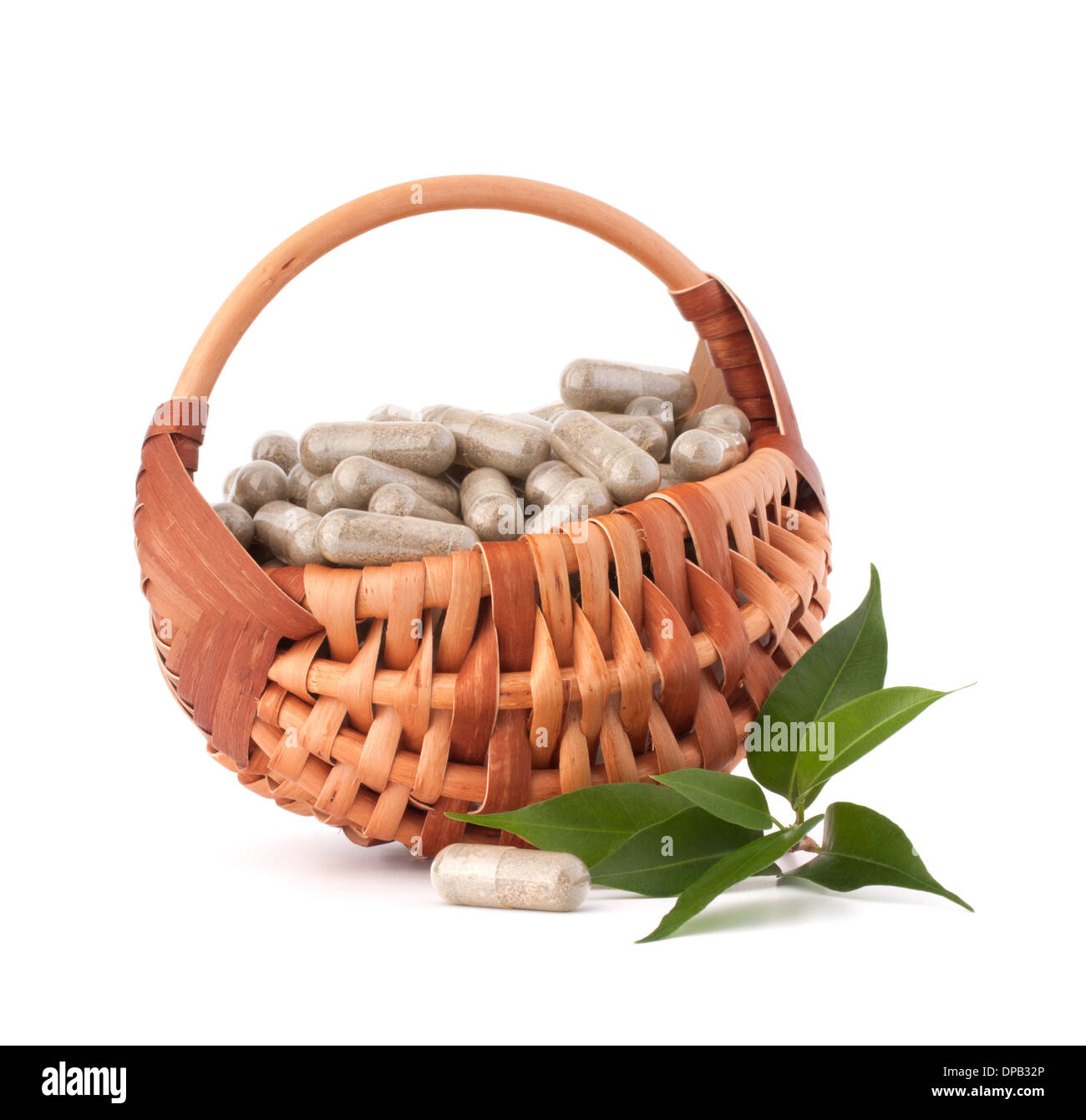 Herbal drug capsules in wicker basket isolated on white background ...