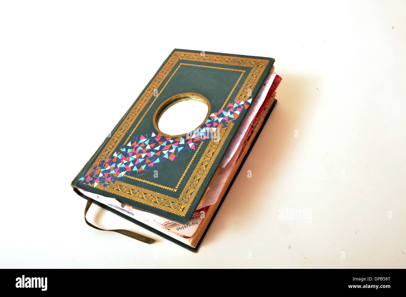 Old book with mirror cutout and painted design Stock Photo - Alamy