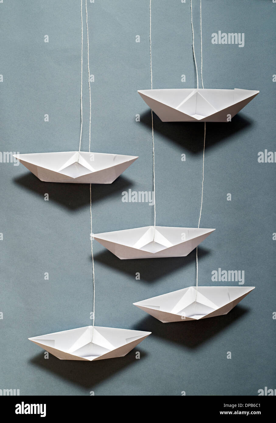 paper boats hung strings on gray background Stock Photo - Alamy