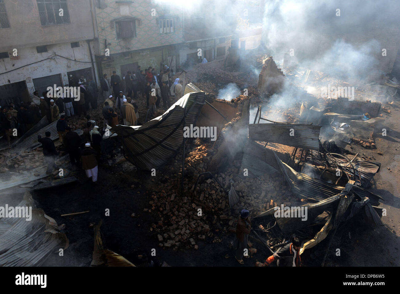 Peshawar, Pakistan. 11th Jan, 2014. People gather at the fire site in ...