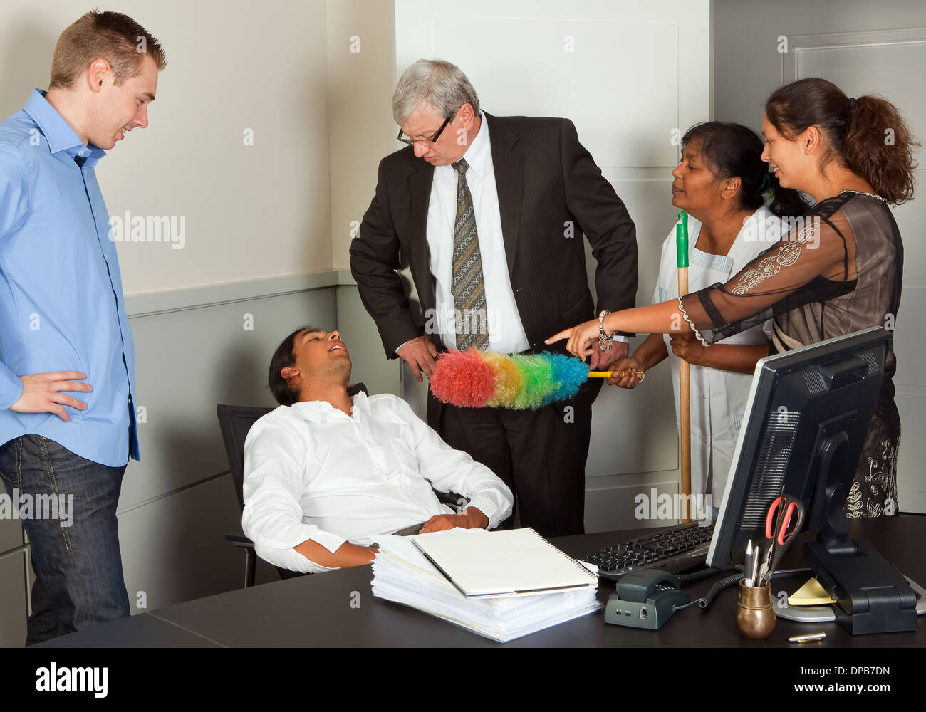 Employees having caught a colleague sleeping at his desk Stock Photo ...