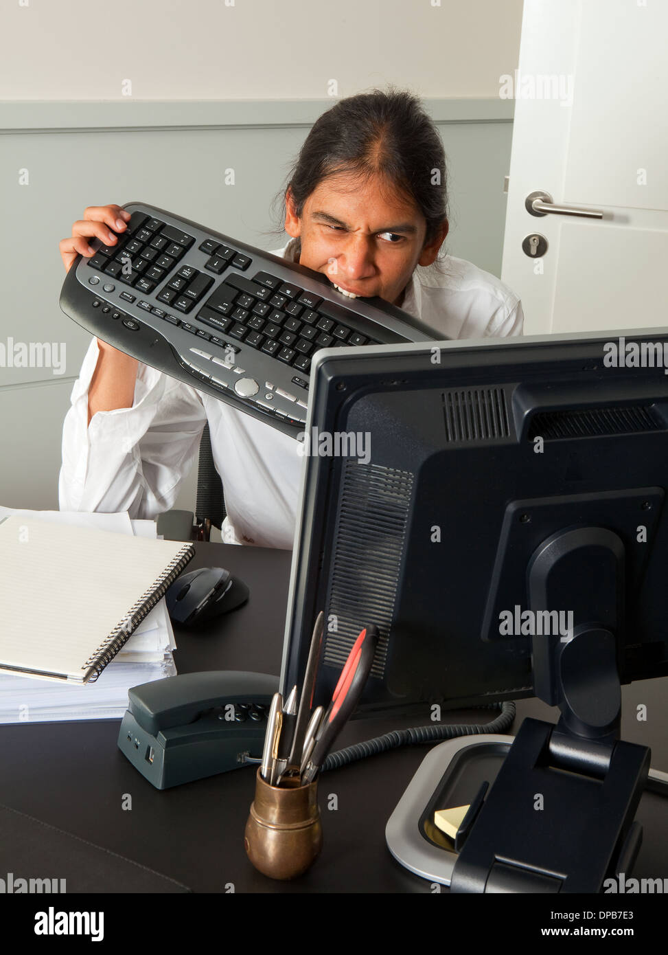 Young frustrated and angry employee chewing on his keyboard Stock Photo ...