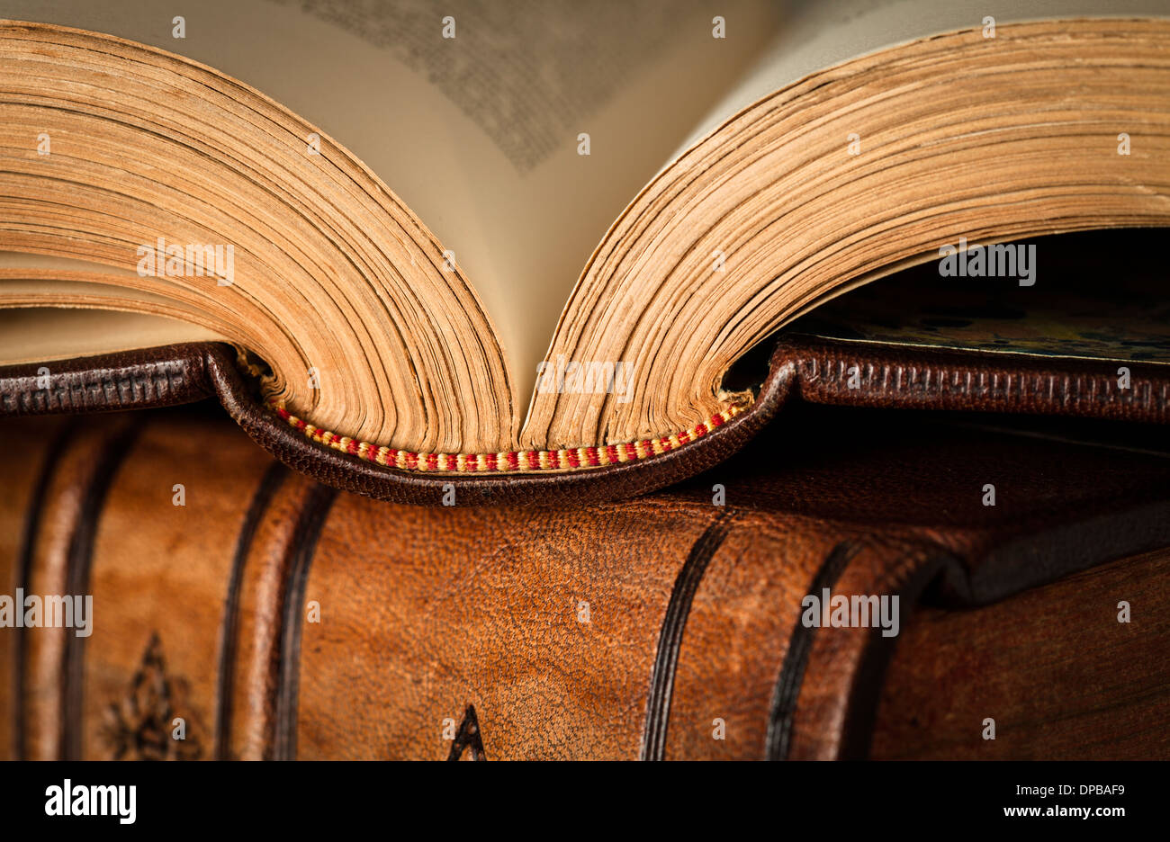 Unidentified old books in brown leather binding with one open showing ...
