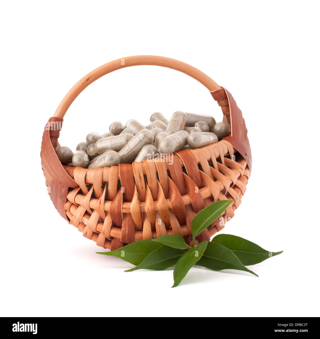 Herbal drug capsules in wicker basket isolated on white background ...