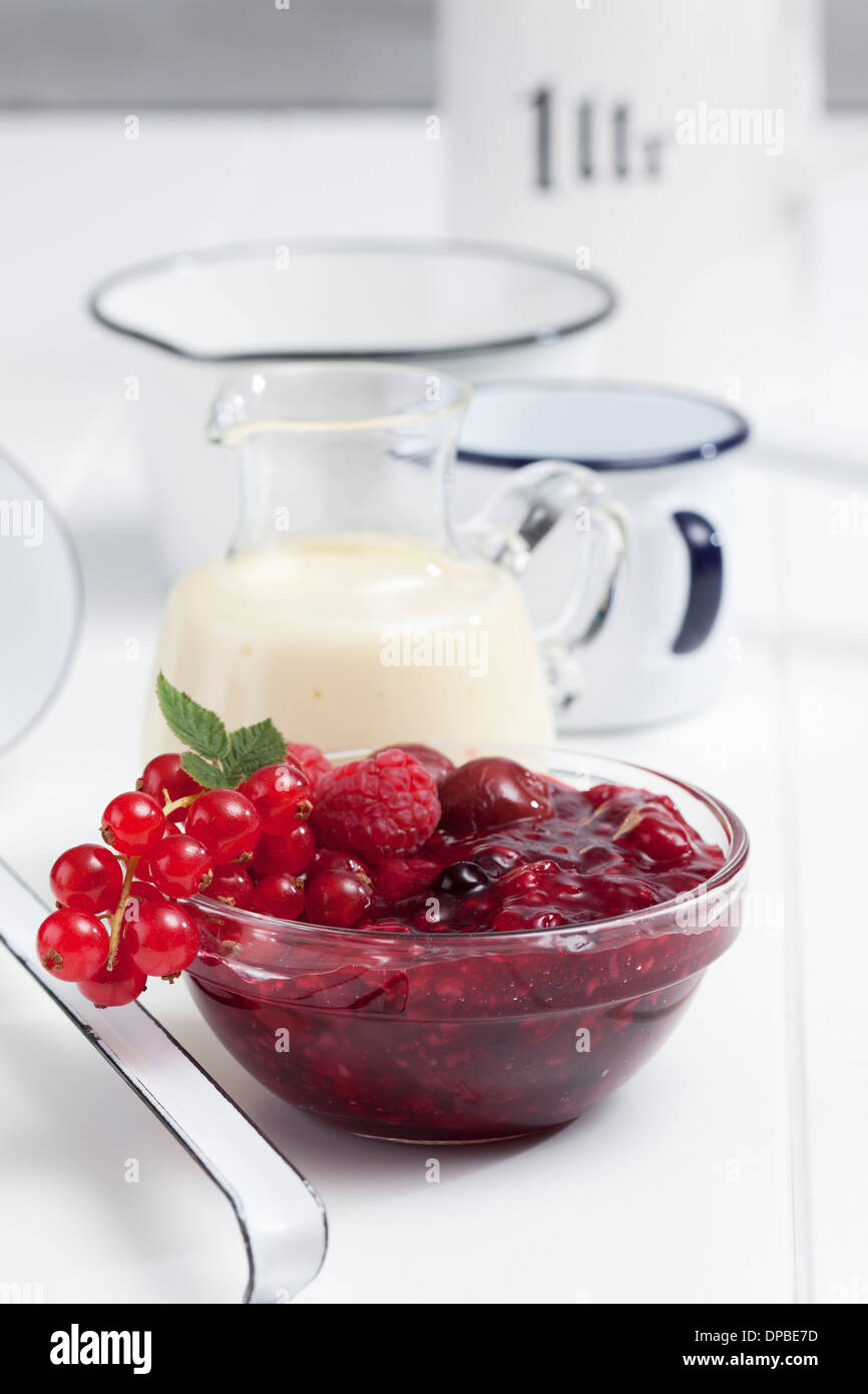 Red berry compote and vanilla sauce on wooden table Stock Photo - Alamy