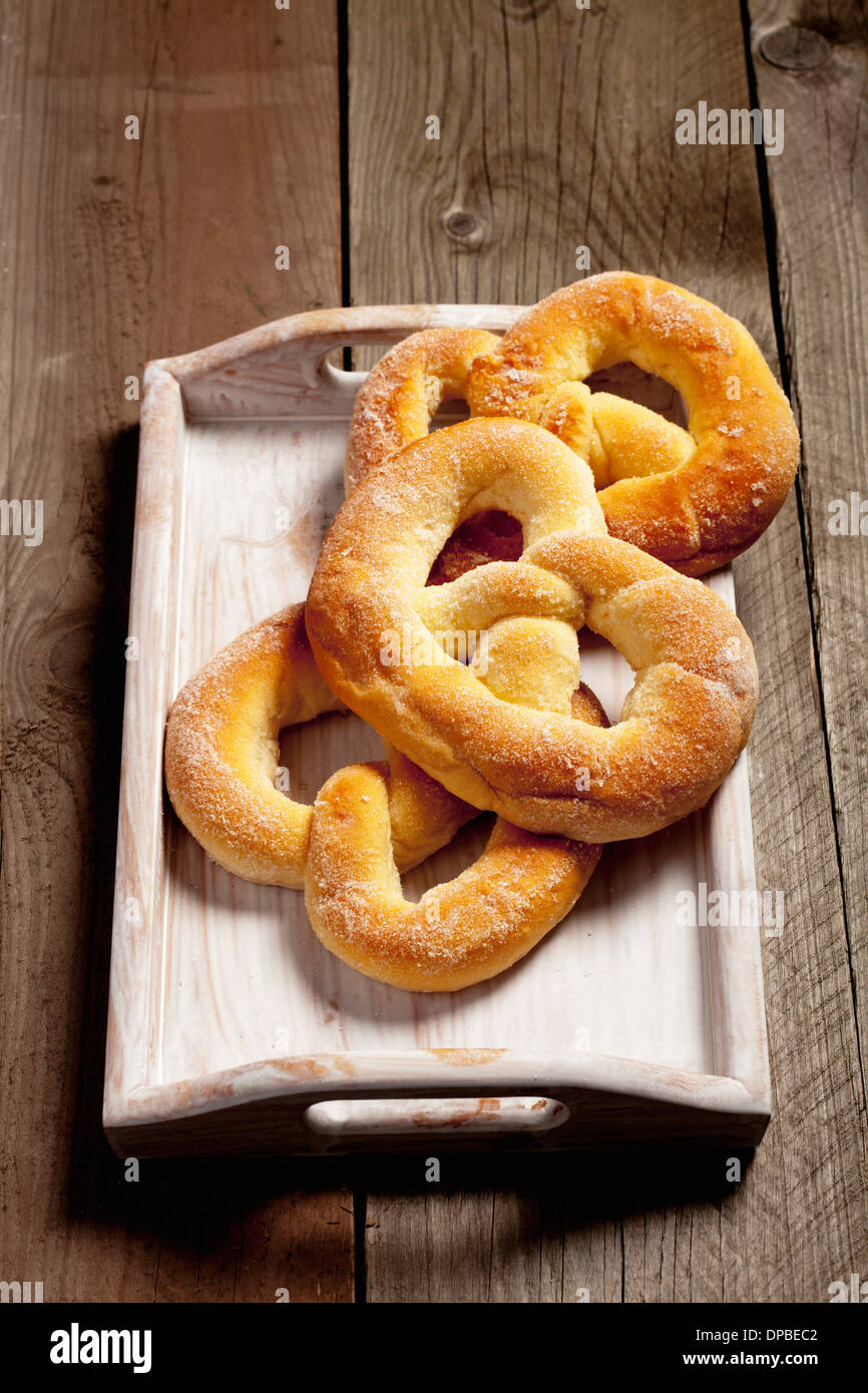 Three sugar pretzels and a tray on wooden table Stock Photo - Alamy