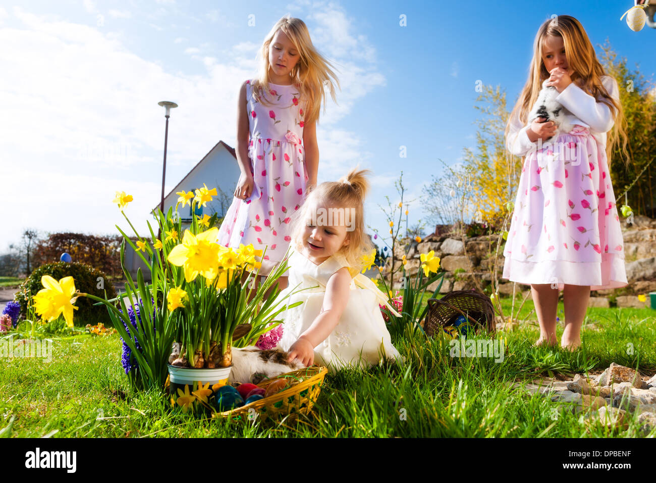 Children on an Easter Egg hunt on a meadow in spring, in the foreground ...