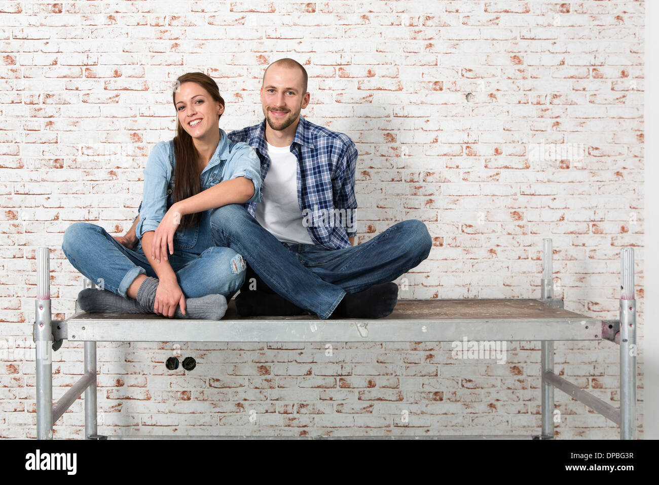 Young couple moving into new home, sitting on rack Stock Photo - Alamy