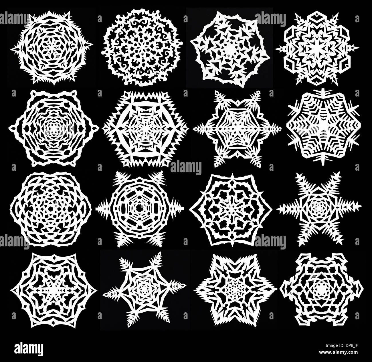 set of hand made cut out white snowflakes on black paper background ...