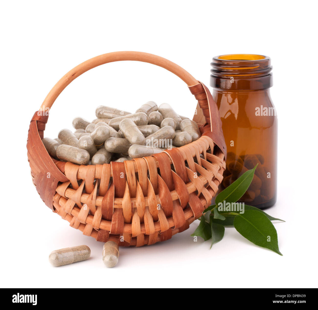 Herbal drug capsules in wicker basket isolated on white background ...