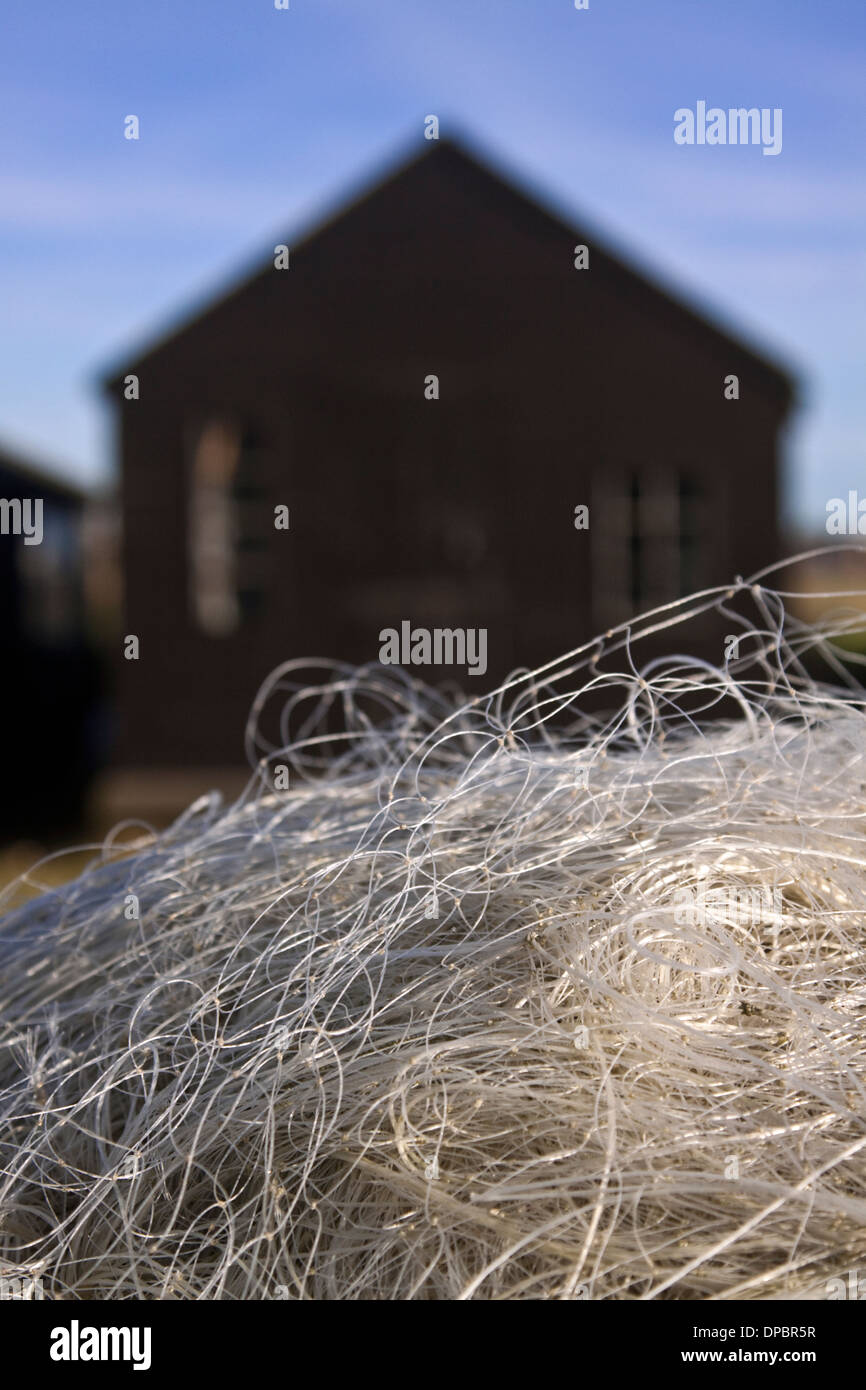 White fishing net with fishermans hut in background Stock Photo - Alamy