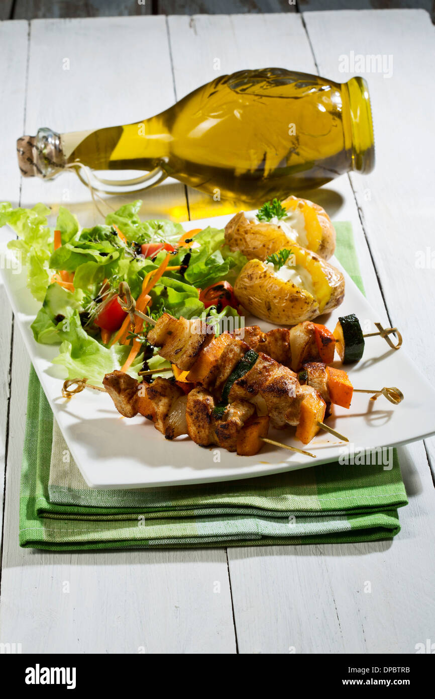 Chicken meat sticks with baked potatoes and mixed salad Stock Photo - Alamy