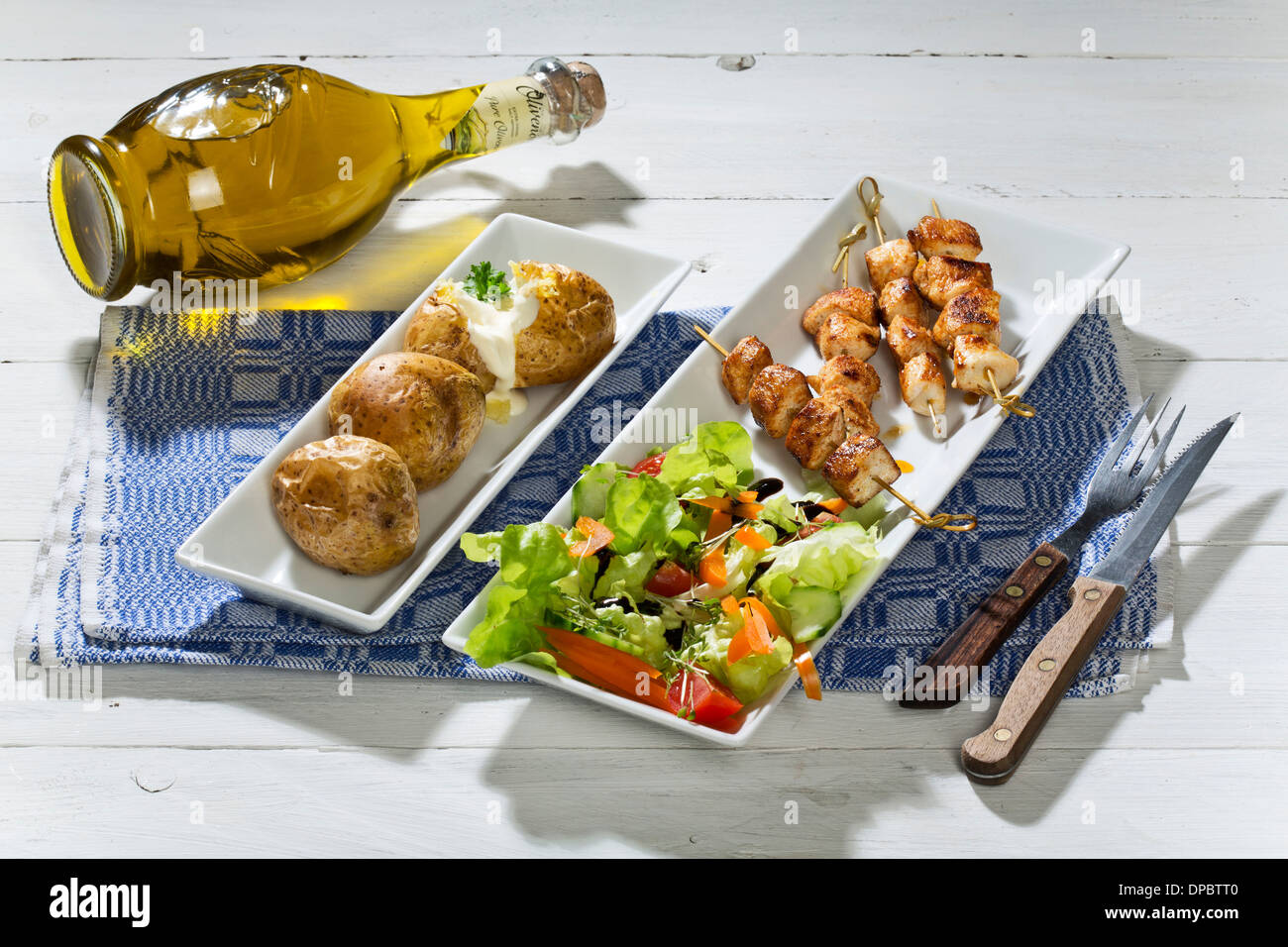 Chicken meat sticks with baked potatoes and mixed salad Stock Photo - Alamy