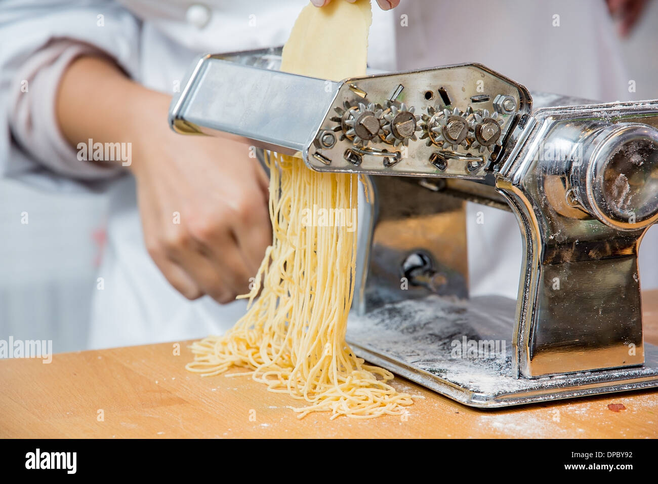 Chief making pasta with a machine Stock Photo - Alamy