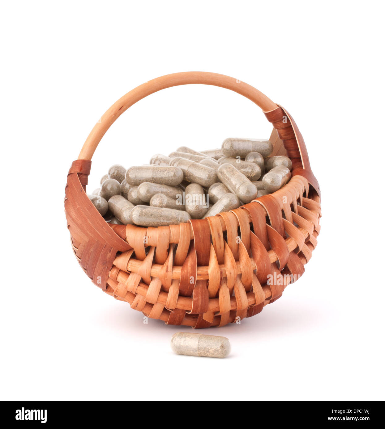 Herbal drug capsules in wicker basket isolated on white background ...