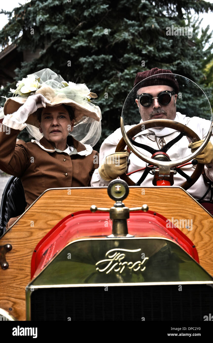 Two people driving a vintage race car Stock Photo - Alamy