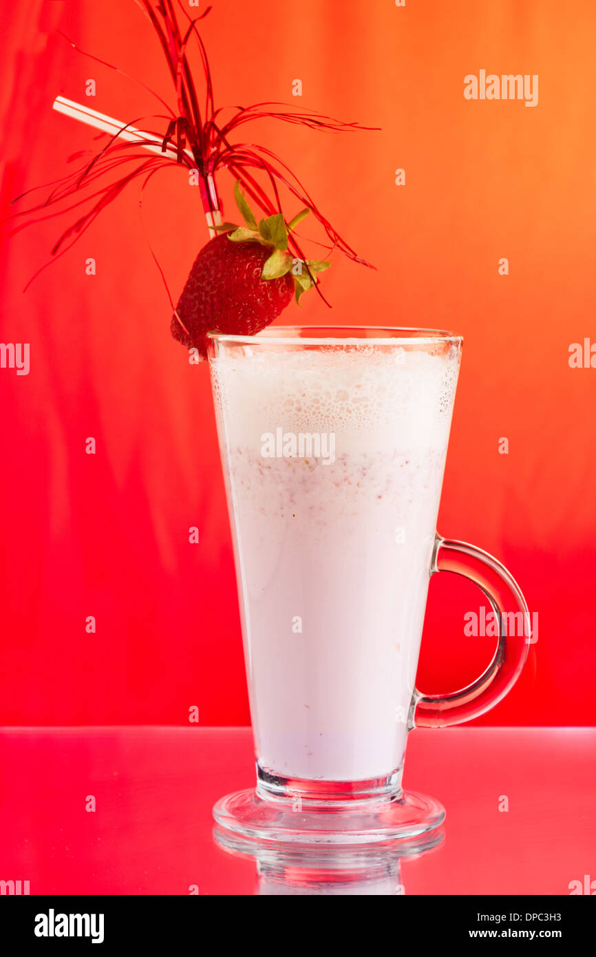 Strawberry milkshake with straw on red Stock Photo - Alamy