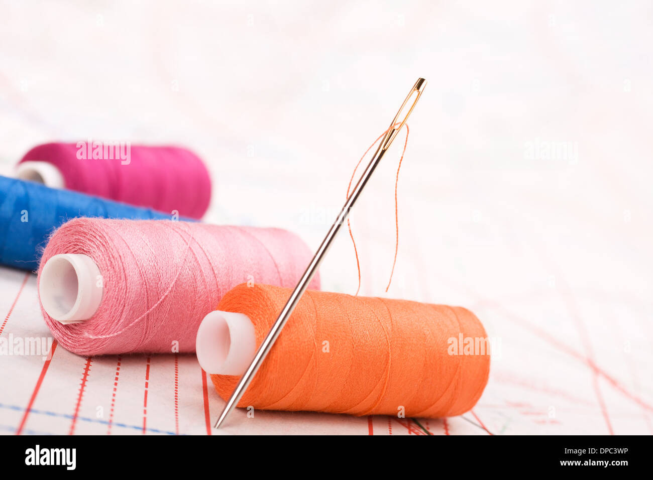 Spool of thread and needle. Sew accessories on blurred background Stock ...