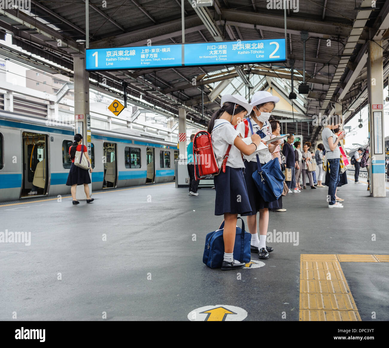 Schoolgirls waiting for the train at a railway station, Tokyo, Japan ...