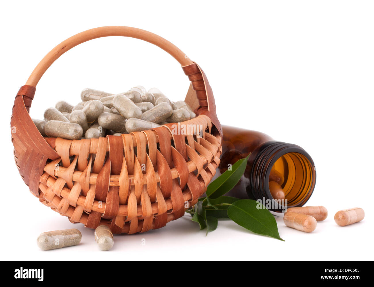 Herbal drug capsules in wicker basket isolated on white background ...