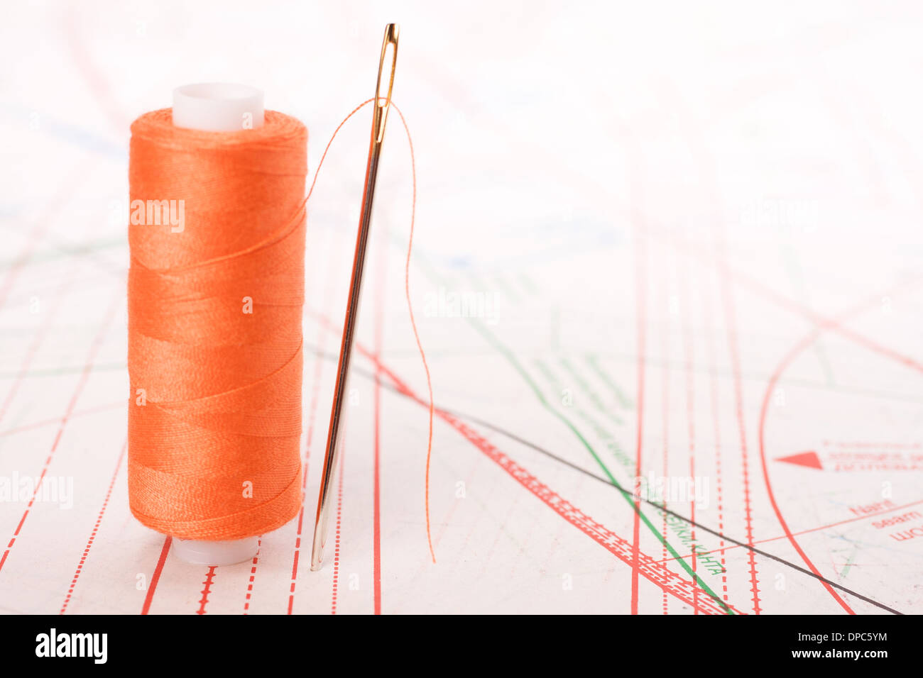 Spool of thread and needle. Sew accessories on blurred background Stock ...