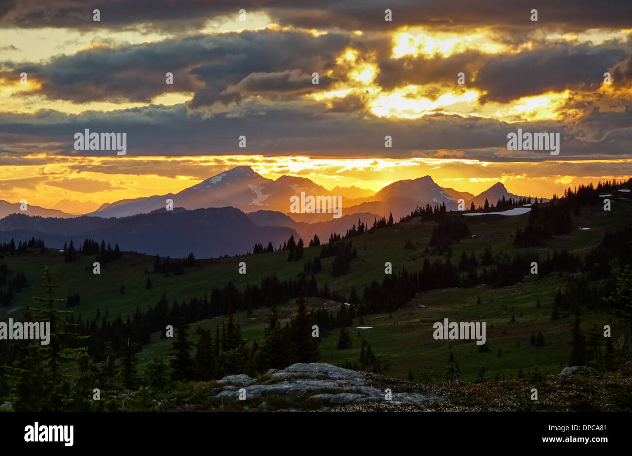 Dramatic sunset rays streaming through a range of mountains Stock Photo ...