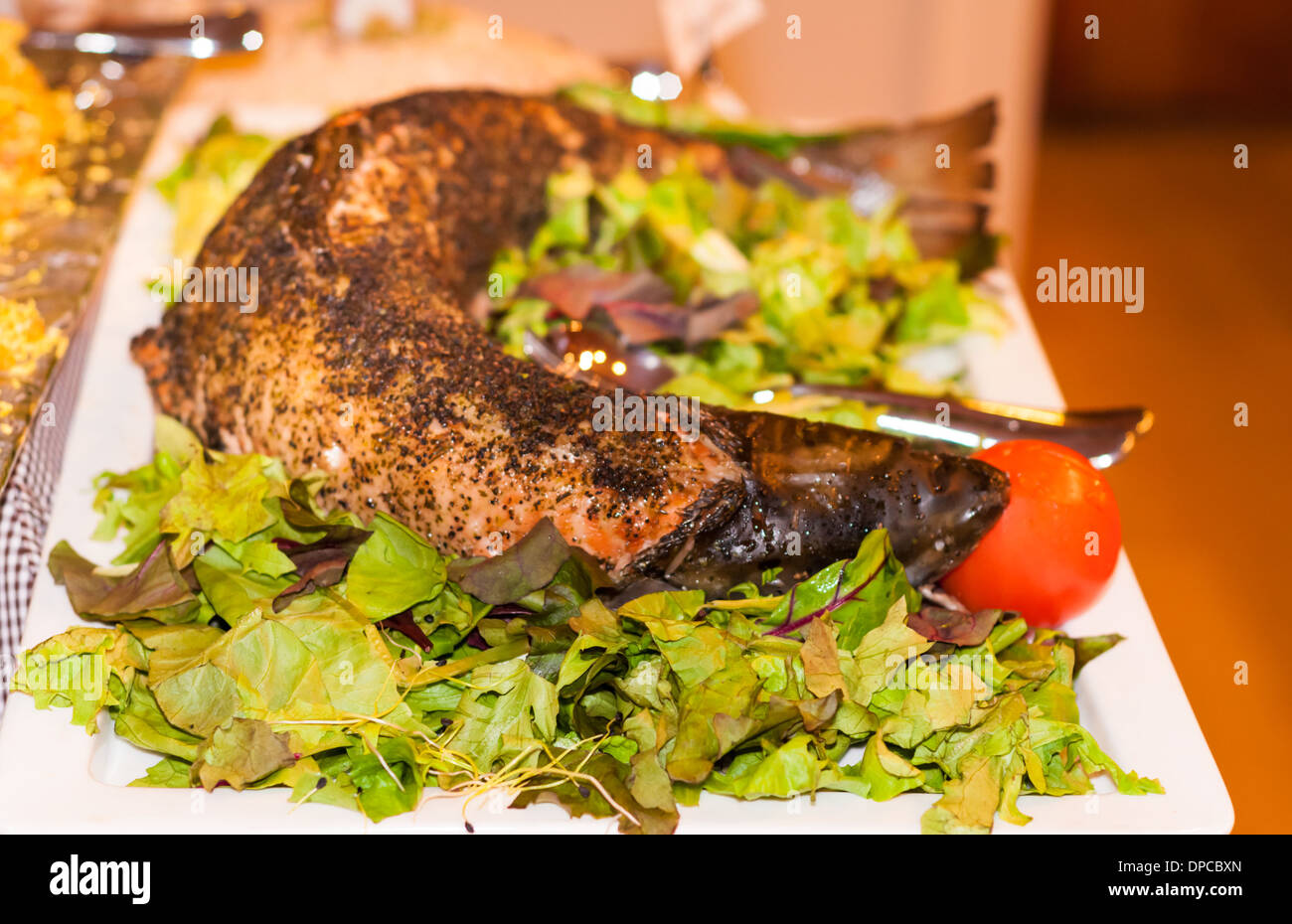 Whole salmon fish cooked in oven with green salad Stock Photo - Alamy