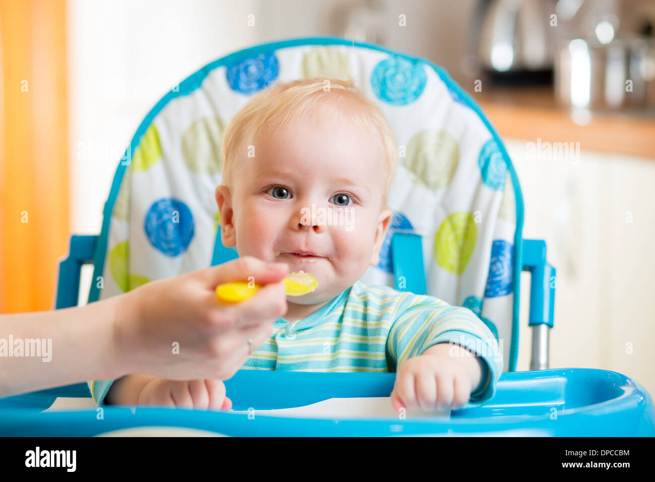 mother spoon feeding baby boy Stock Photo - Alamy