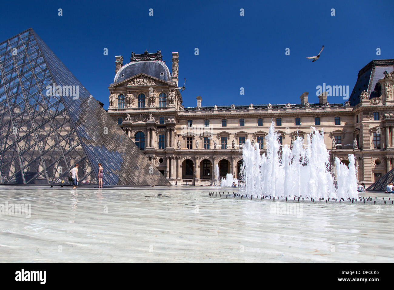 The glass and metal pyramid at the Courtyard of the Louvre Museum ...