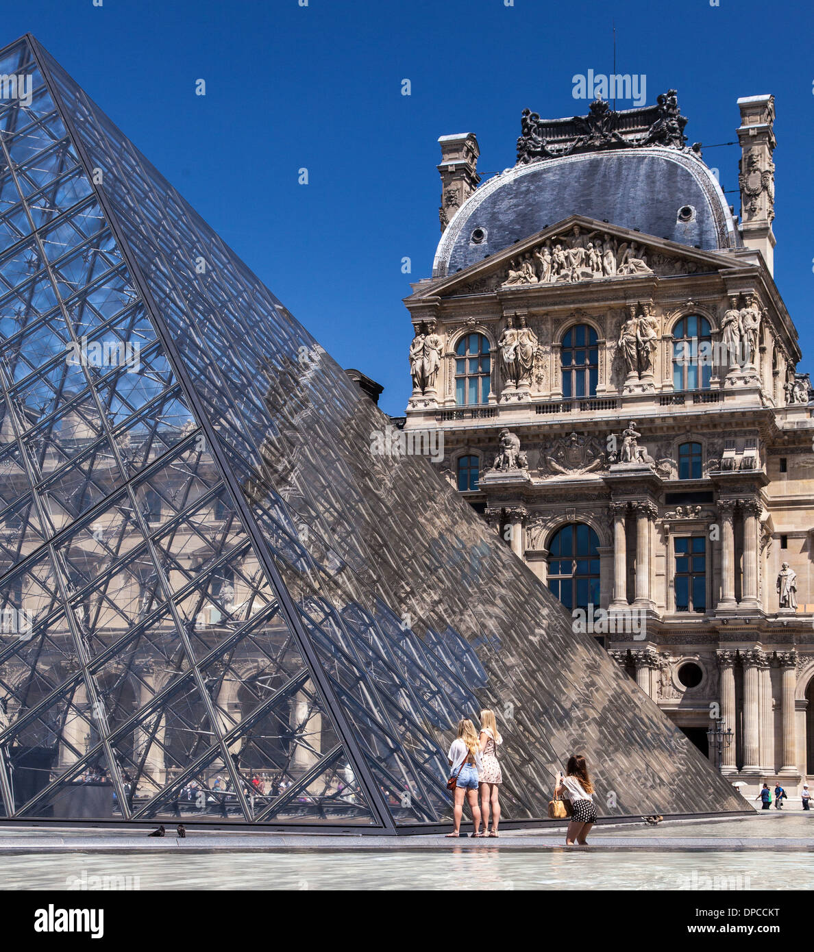 The glass and metal pyramid at the Courtyard of the Louvre Museum ...