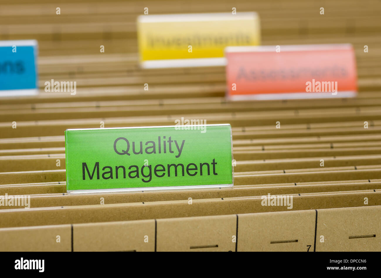 Hanging file folder labeled with Quality Management Stock Photo - Alamy