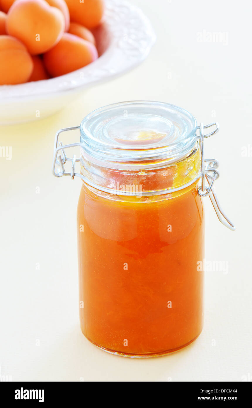 Fresh ripe apricots and homemade apricot jam in a jar in vertical ...