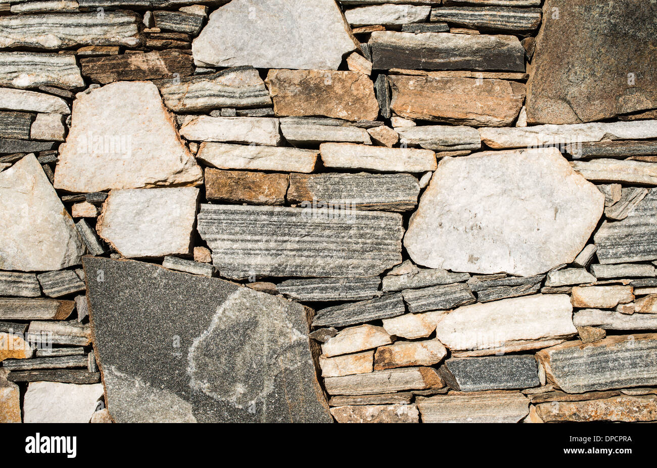 Wall built of stones. Densely arranged stones. Sun light Stock Photo ...