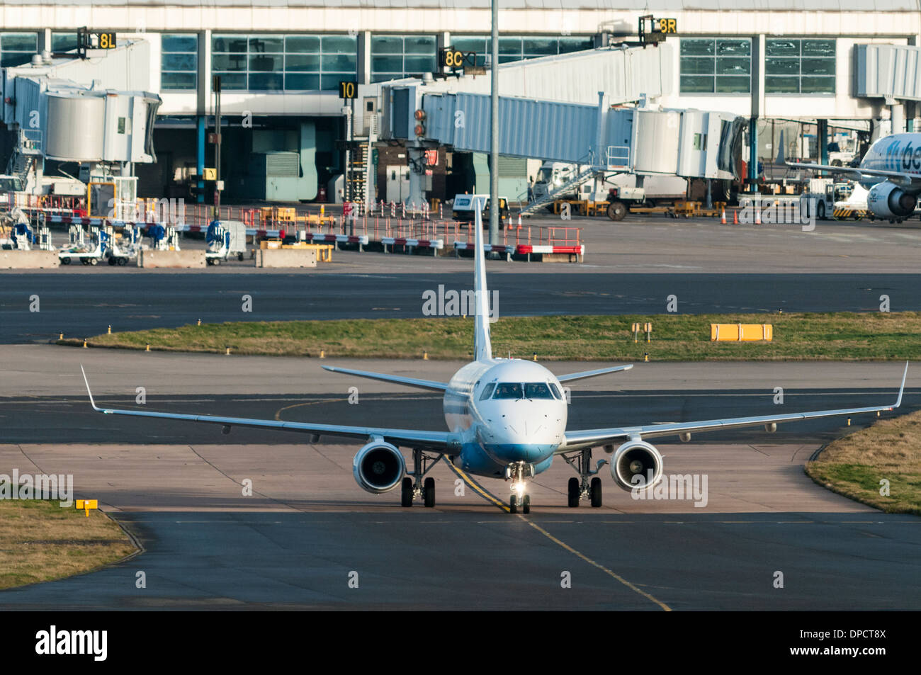 Flybe Embraer ERJ 190 airplane on a taxiway in front of the terminal ...