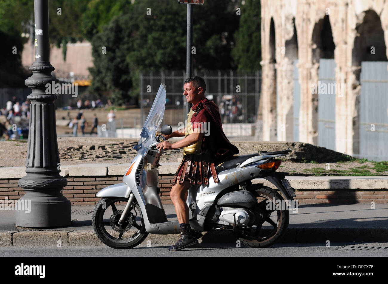 A Roman soldiers sitting on a moped outside the coliseum in Rome, Italy ...