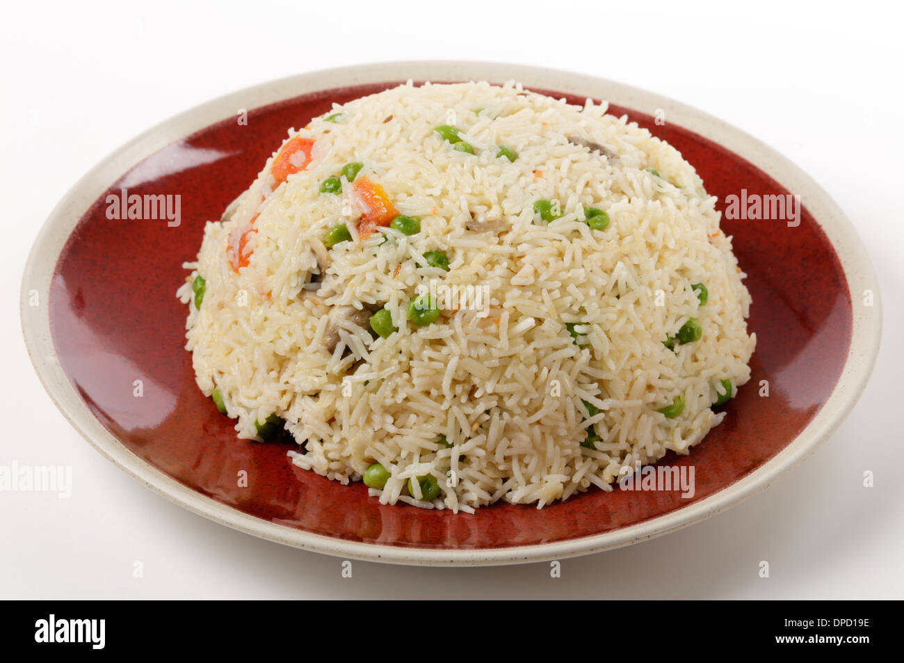 A moulded dome of vegetable pilau rice on a plate ready for serving ...