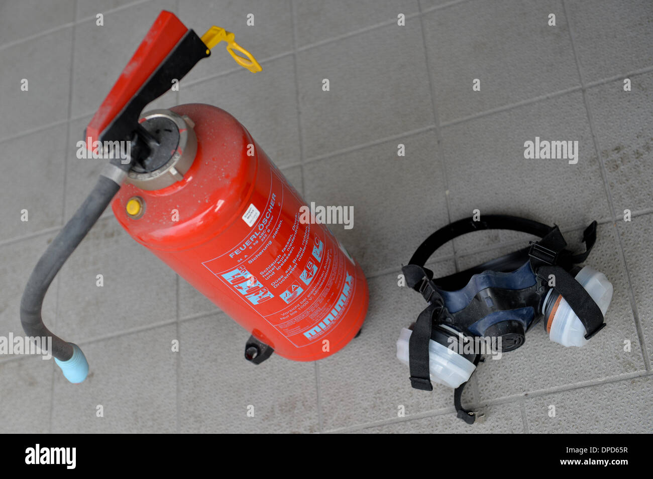 A fire extinguisher and a breathing mask lie on the floor during a fire ...