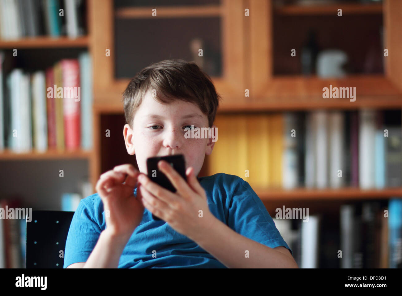 young boy watching to a mobile phone at home Stock Photo - Alamy