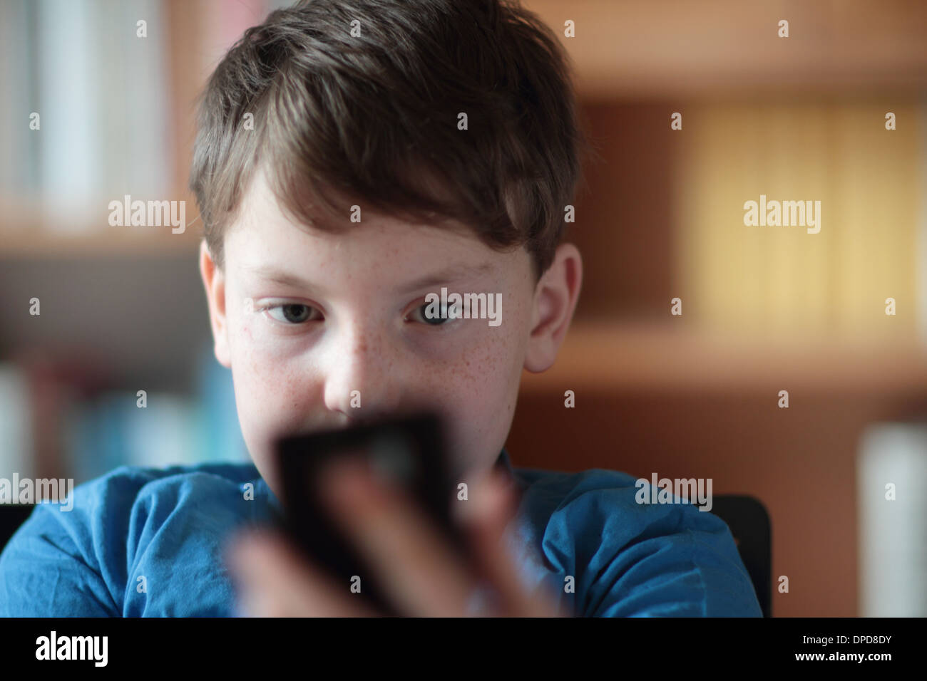 young boy watching to a mobile phone at home Stock Photo - Alamy