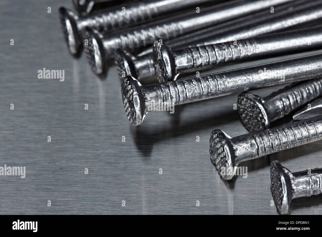 Steel nails on metal plate Stock Photo - Alamy