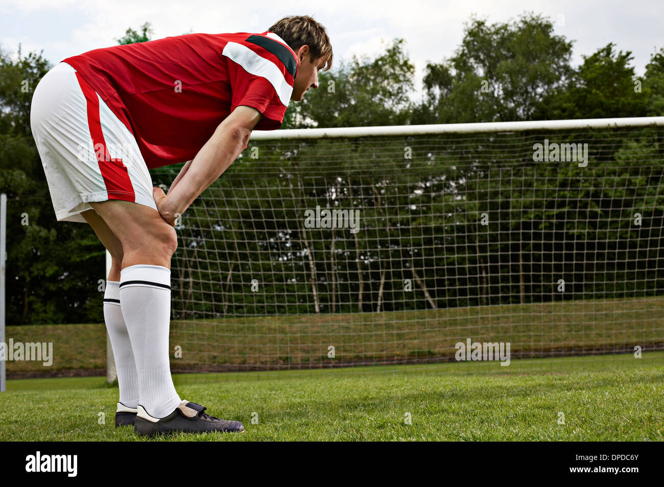 Exhausted soccer player on field Stock Photo - Alamy