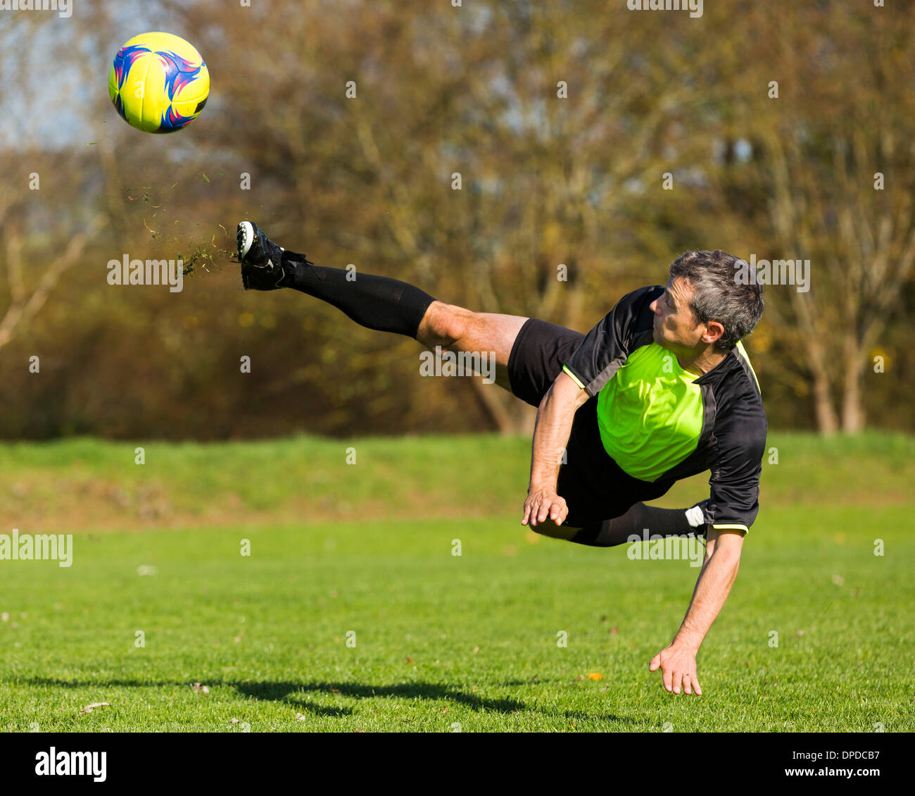 Soccer player kicking ball Stock Photo - Alamy